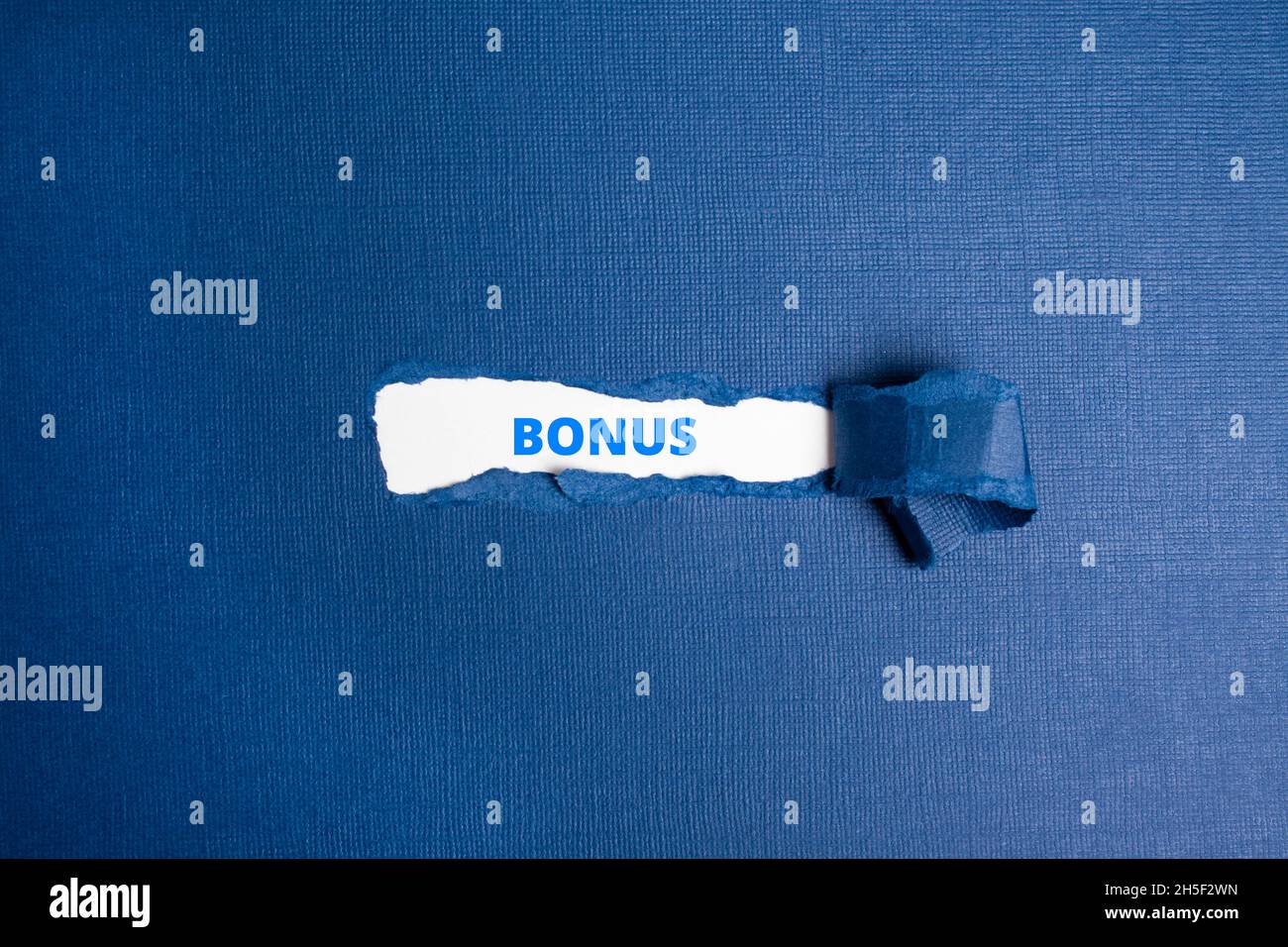Writing text Bonus on blue torn paper Stock Photo - Alamy