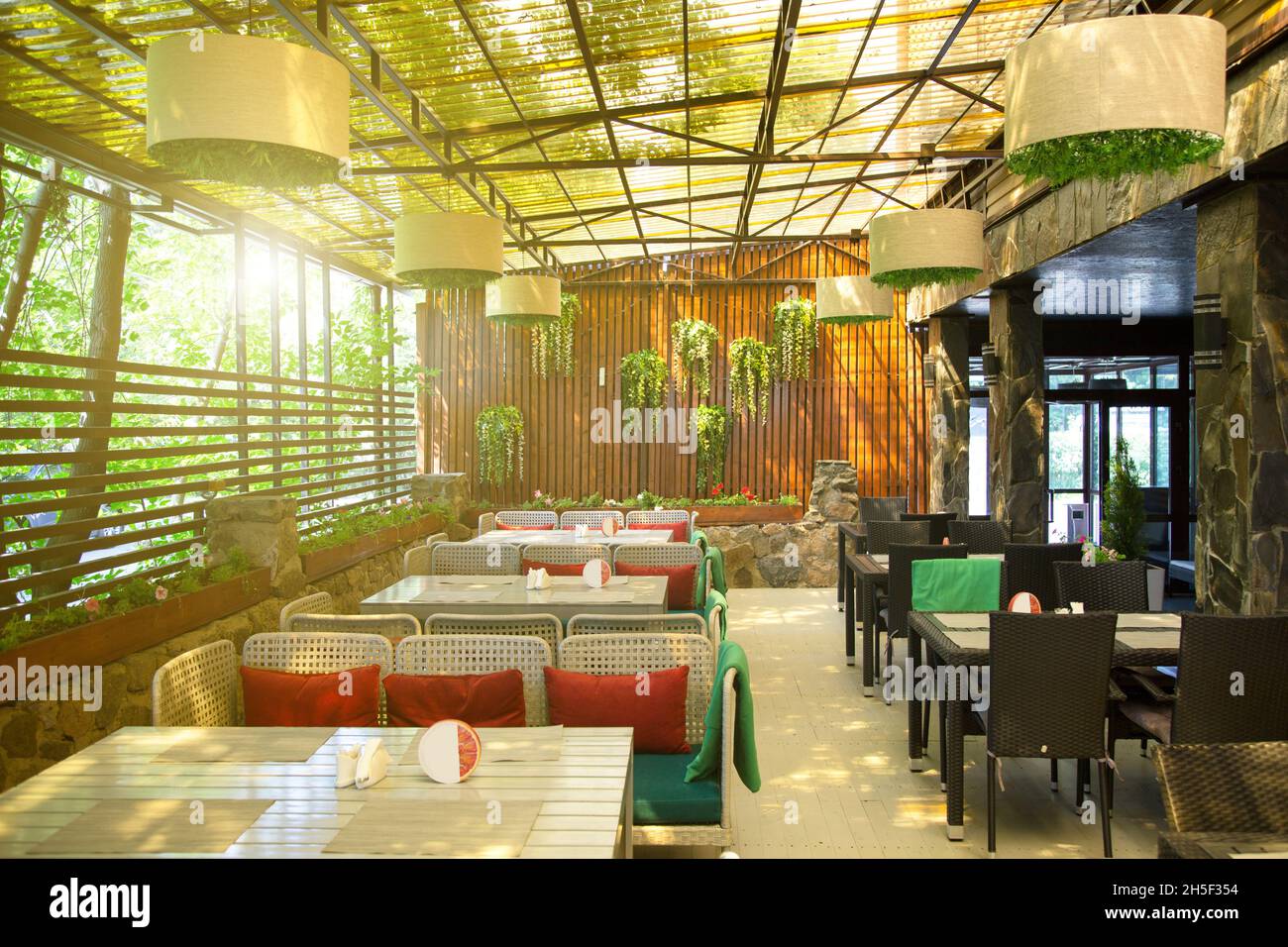 Beautiful outdoor restaurant on the veranda with a wall decorated with ...