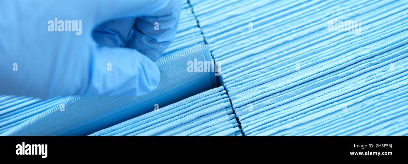 Doctor hand in rubber gloves pulling out sterile disposable napkin from ...