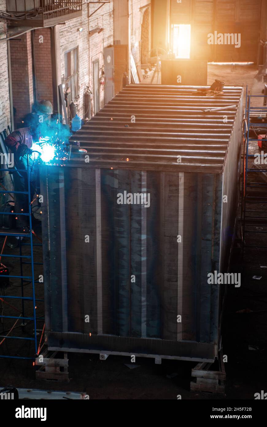 Welder collects a large metal container Stock Photo - Alamy
