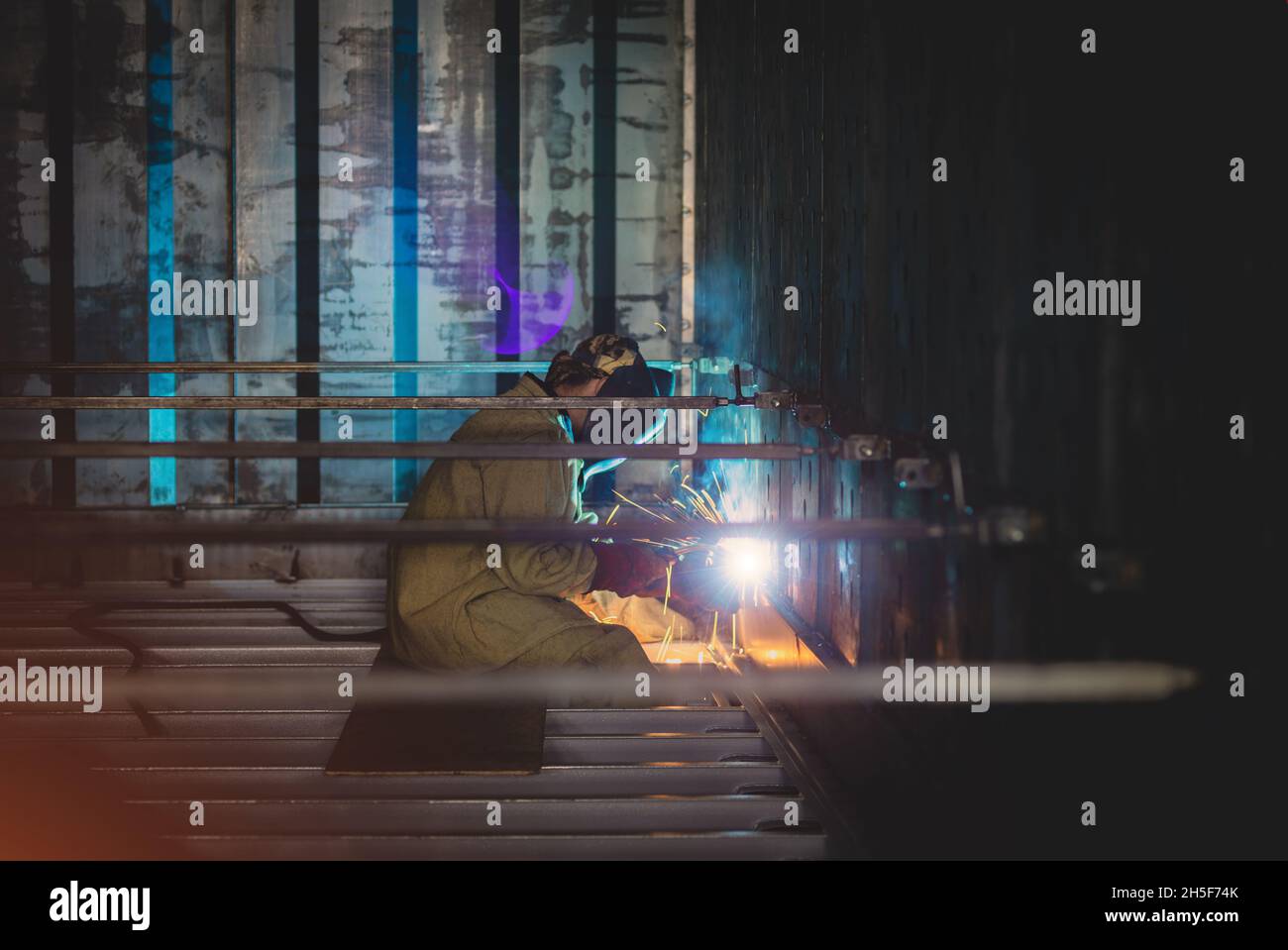 Welder makes welding inside an iron container Stock Photo - Alamy