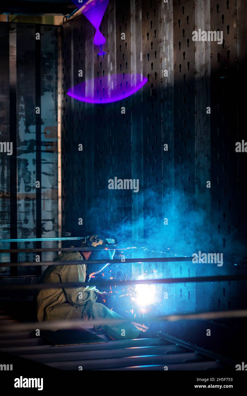 Welder makes welding inside an iron container Stock Photo - Alamy