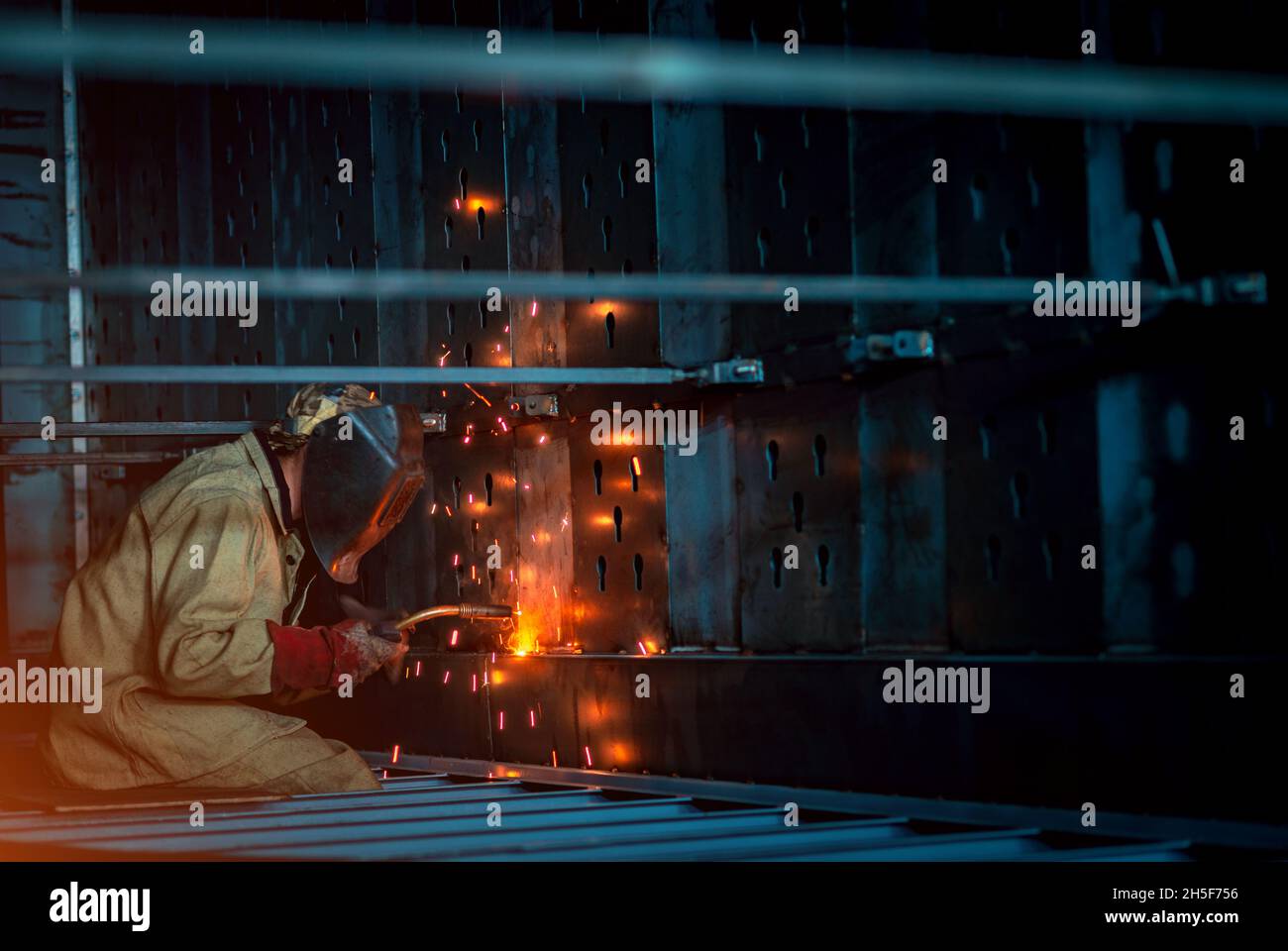 Welder makes welding inside an iron container Stock Photo - Alamy