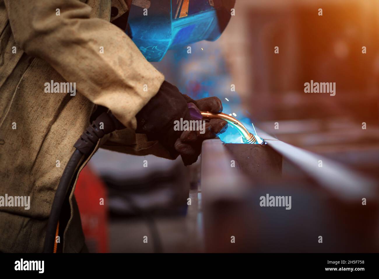A welder with a welding machine works in a factory Stock Photo - Alamy
