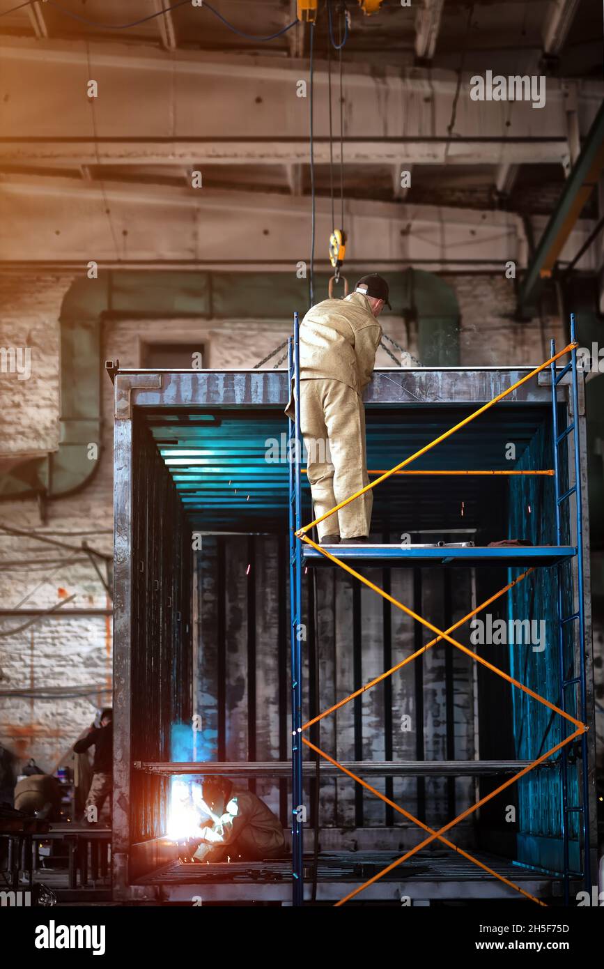 Worker at the factory to weld the iron container Stock Photo - Alamy