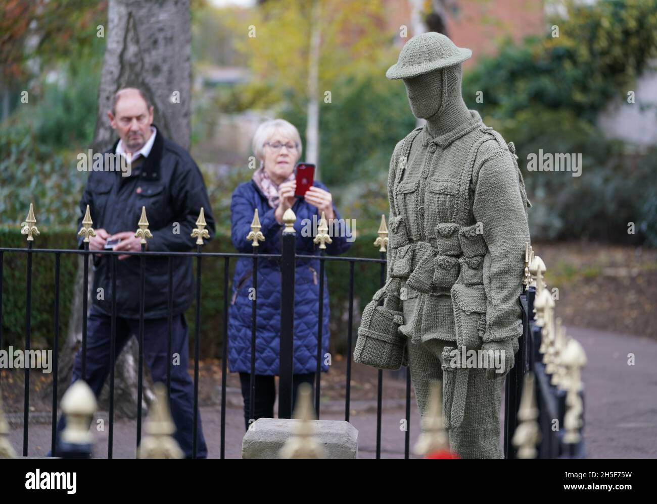 Passers-by look at a life-sized knitted soldier which has been placed ...