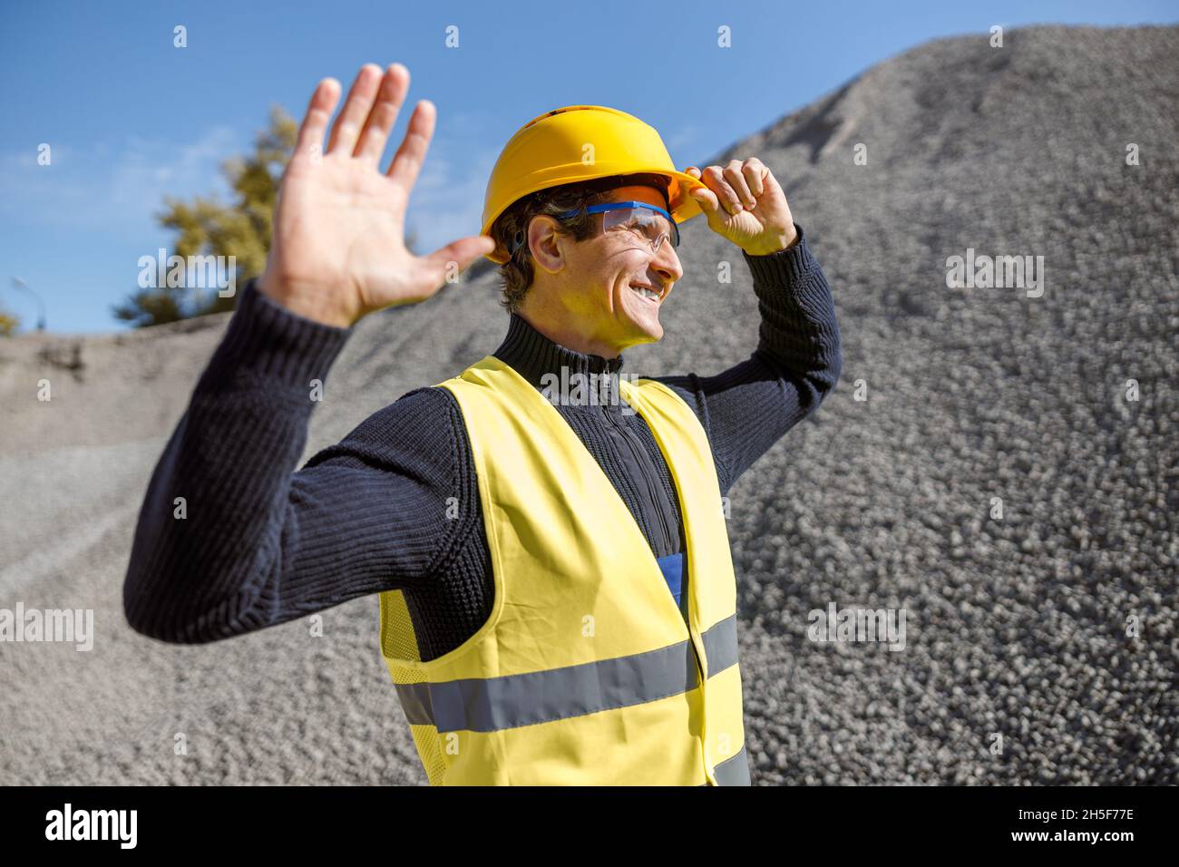 Cheerful male engineer standing outdoors at cement factory Stock Photo ...