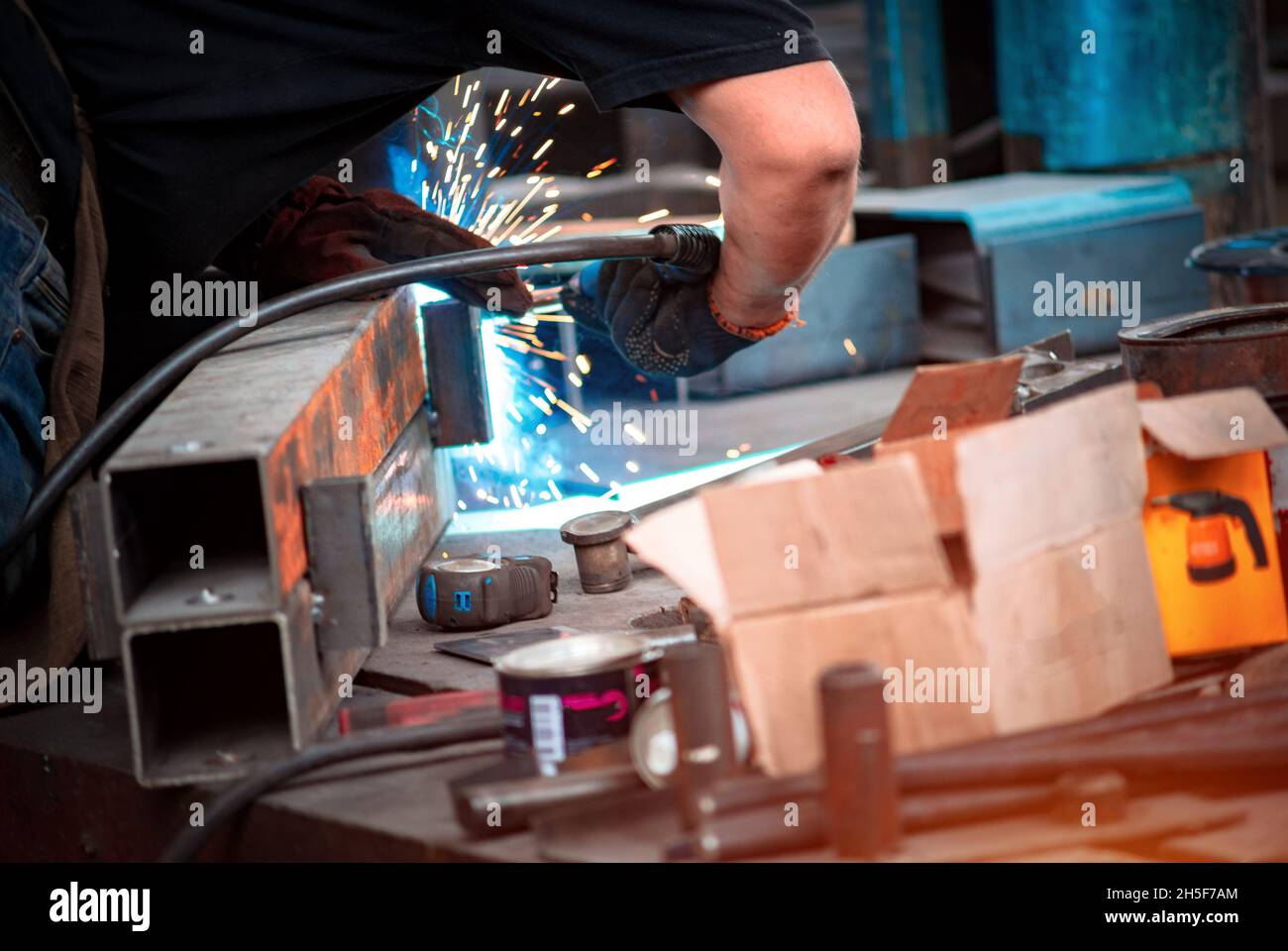 Welder welds two iron bars to each other Stock Photo - Alamy