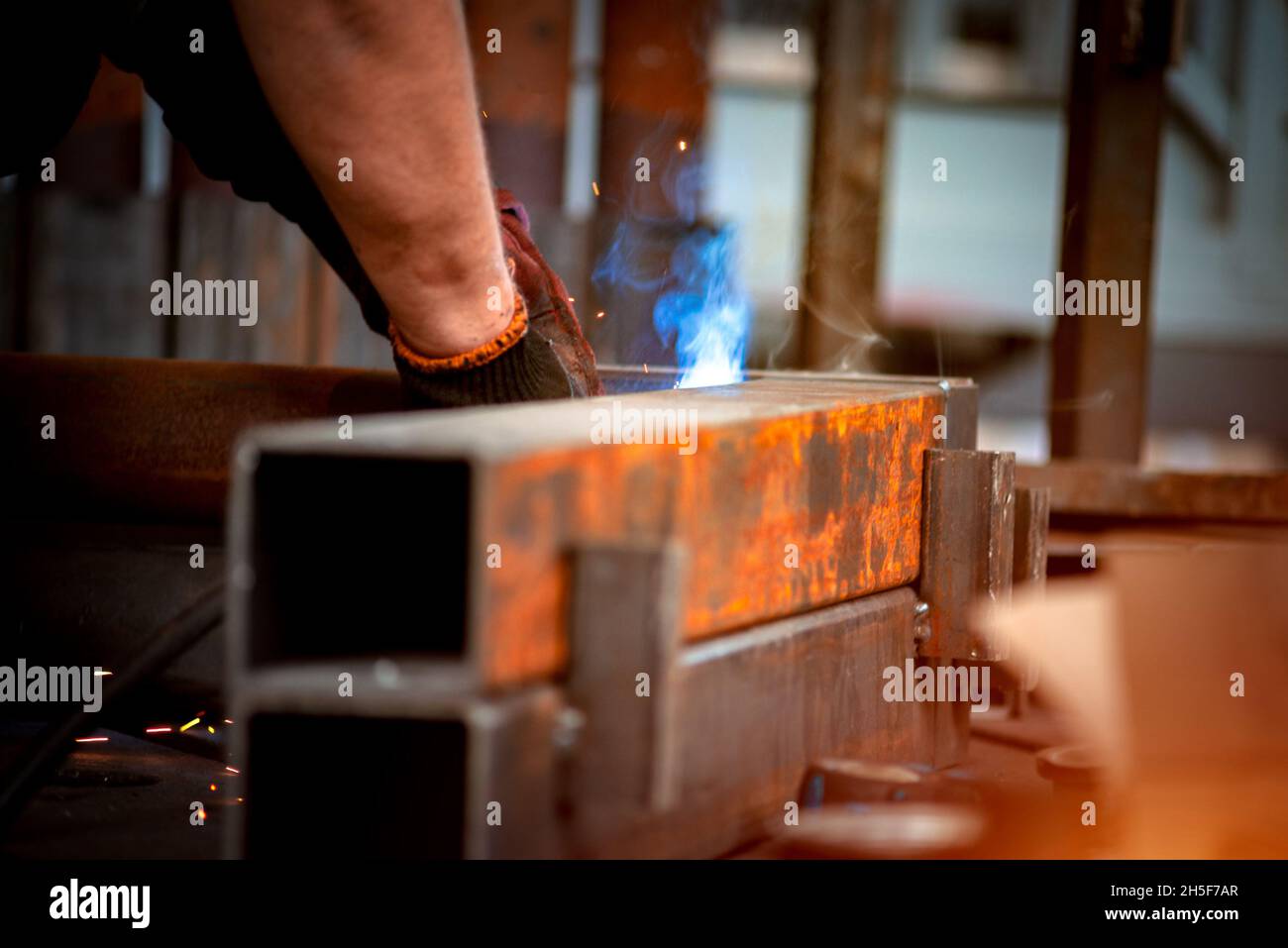 Welder welds two iron bars to each other Stock Photo - Alamy
