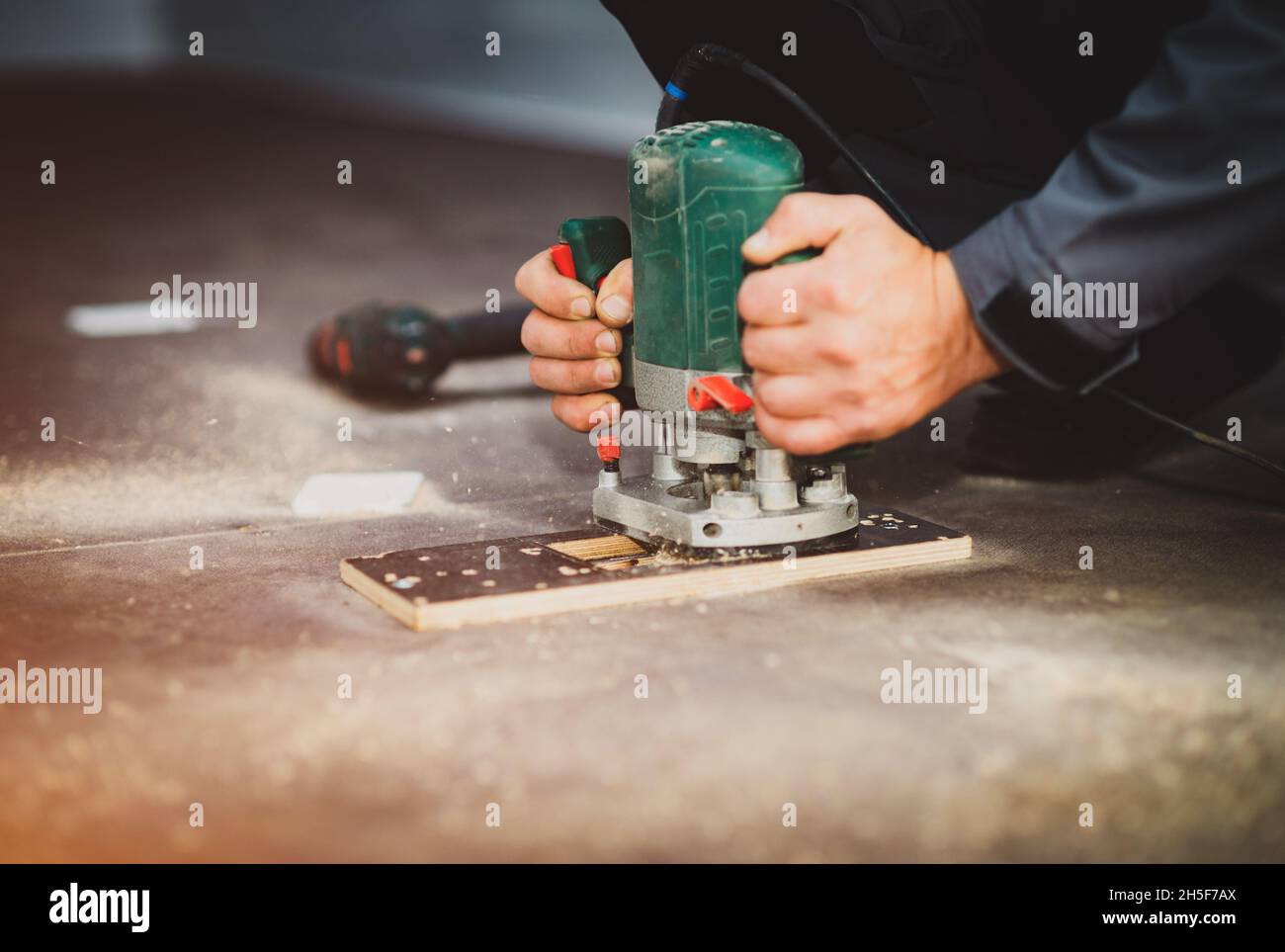 Worker polishes wood with a hand-held electric tool Stock Photo - Alamy
