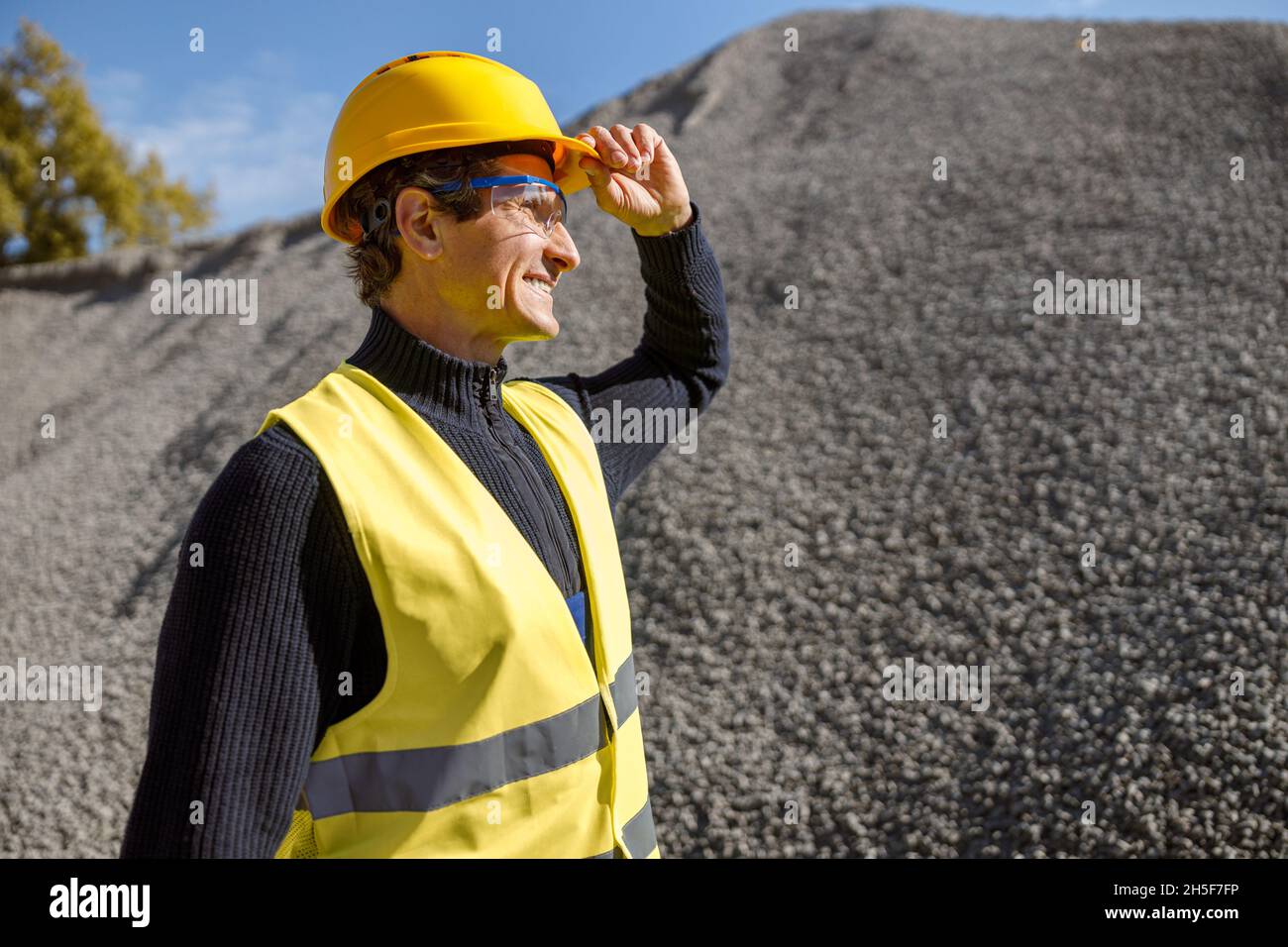 Joyful man engineer standing outdoors at cement factory Stock Photo - Alamy