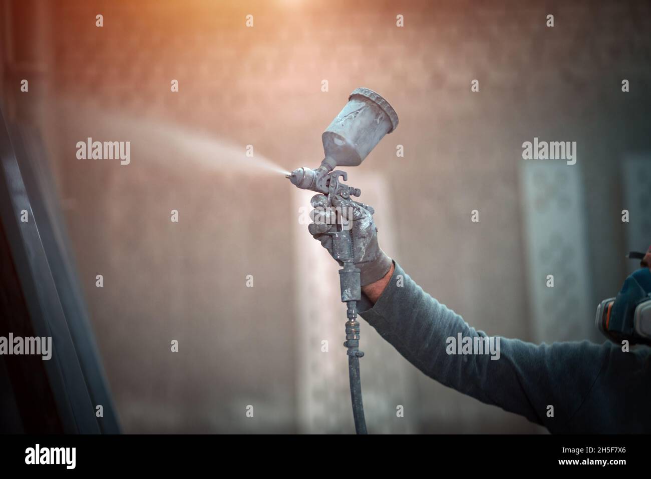 Man painting metal products with a spray gun Stock Photo - Alamy