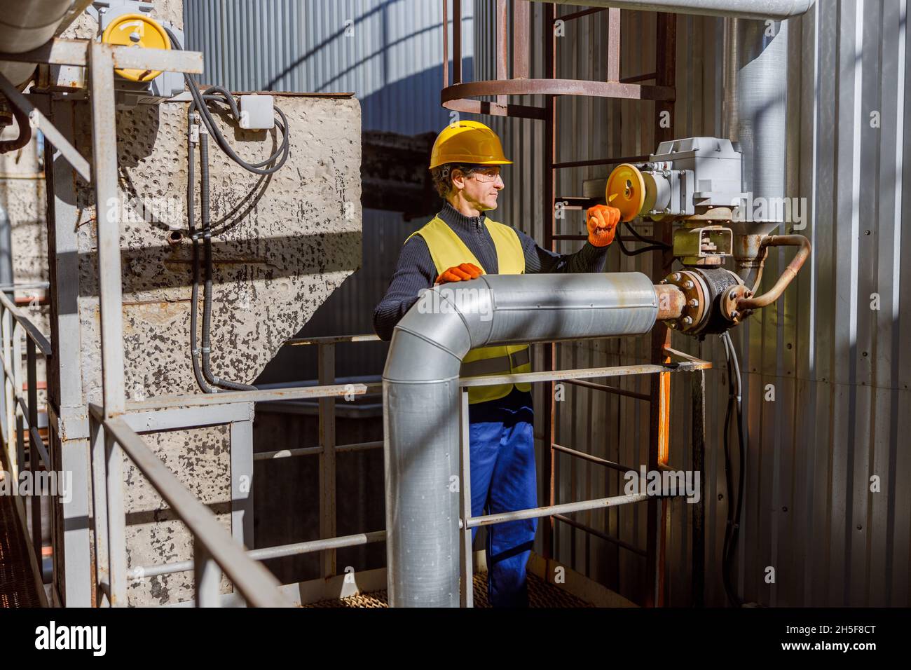 Male engineer in safety helmet working at factory Stock Photo - Alamy