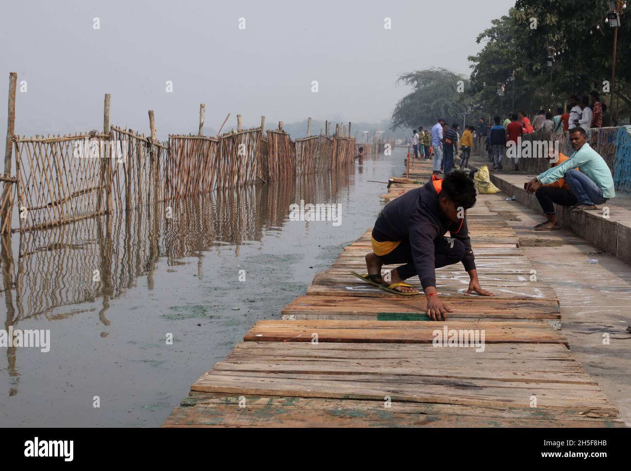 A devotee adjusts the wooden platform during the preparation of the ...