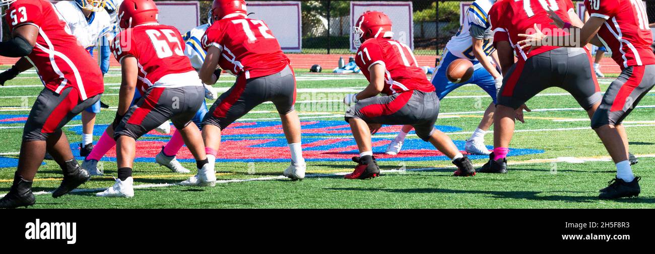 High school football game with the quarterback receiving the ball in ...