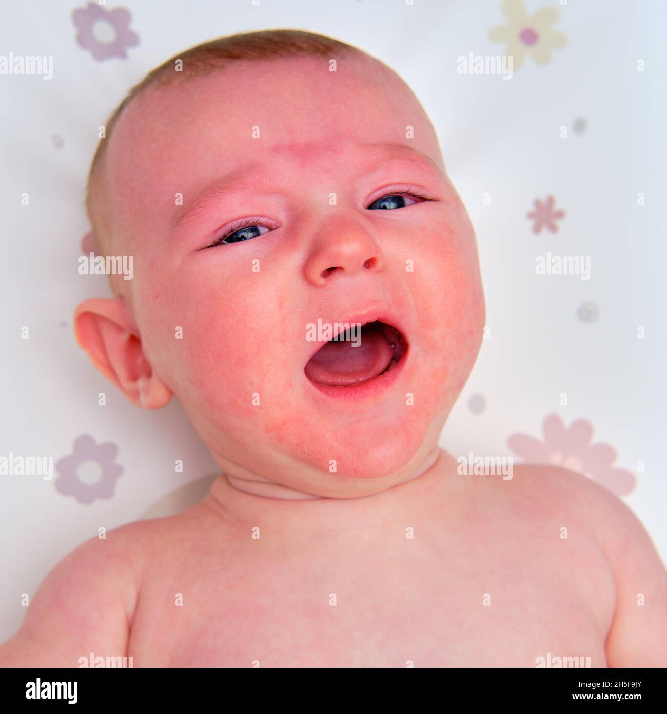 Crying Infant baby boy at the age of four months, close-up portrait ...