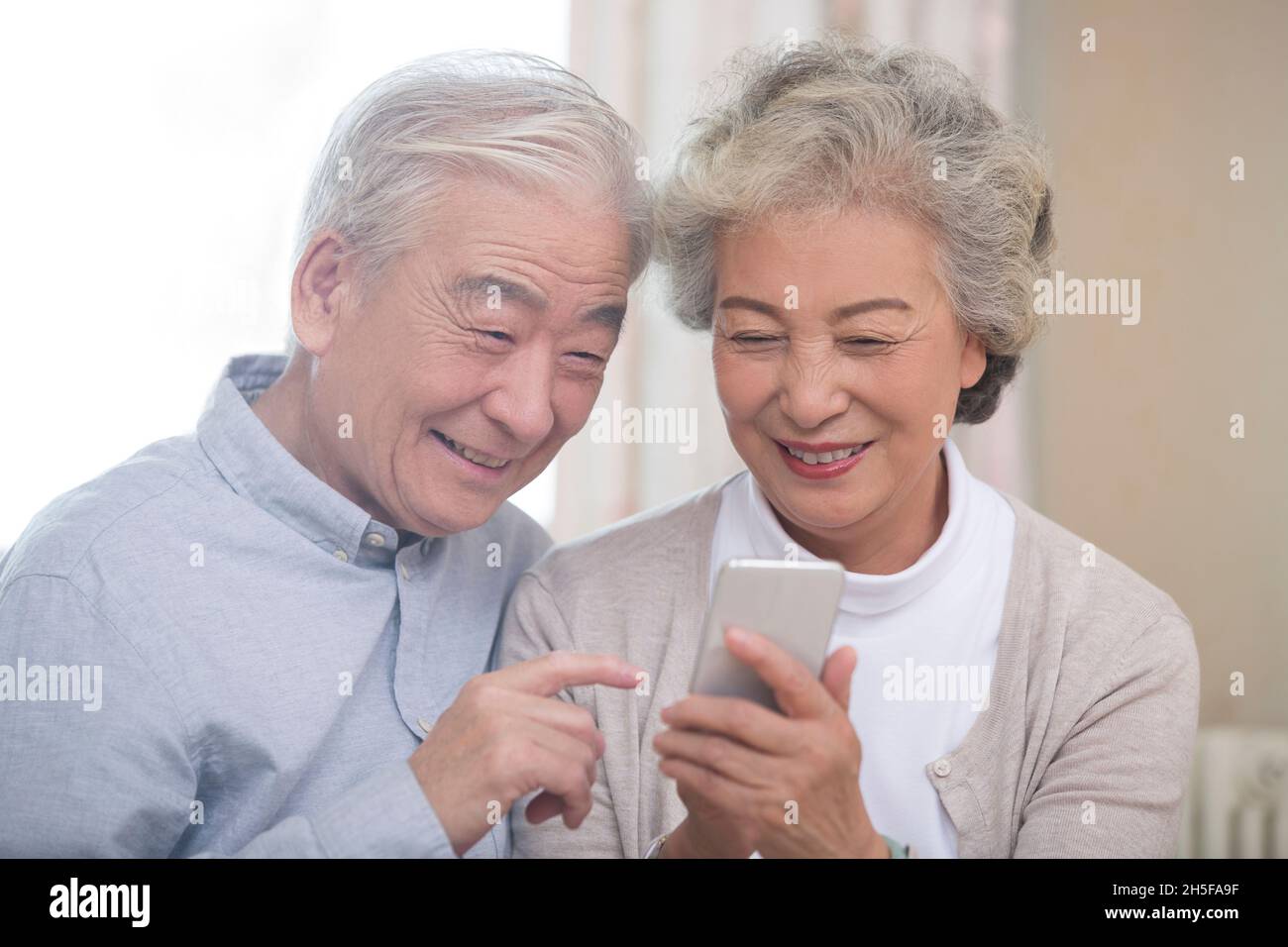 Happy elderly couple having video call on their cell phone Stock Photo ...