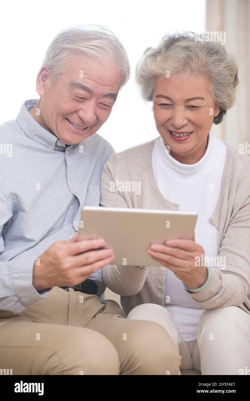 Happy elderly couples using tablets Stock Photo - Alamy