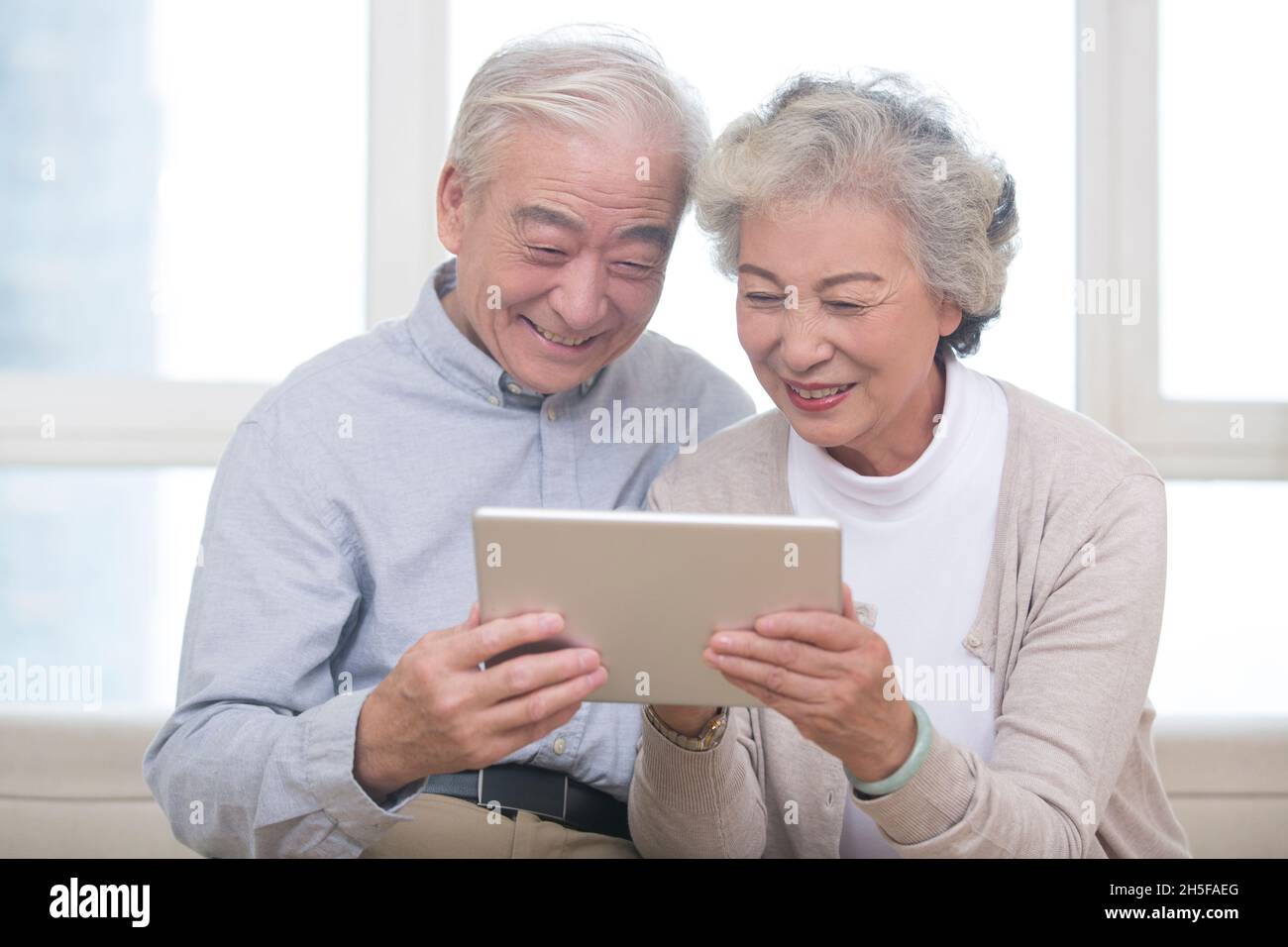 Happy elderly couples using tablets Stock Photo - Alamy