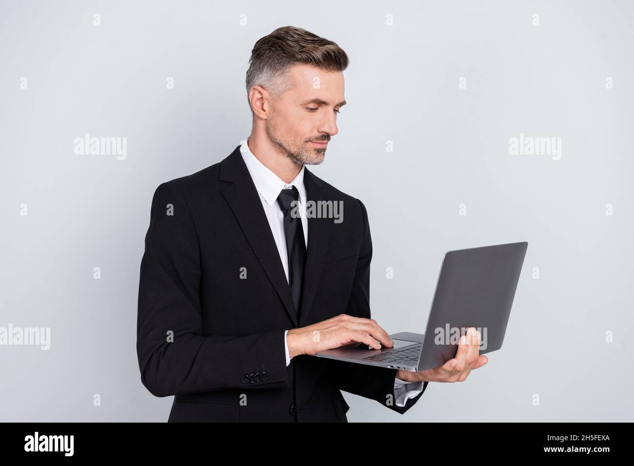 Photo of serious confident young programmer wear black jacket typing ...