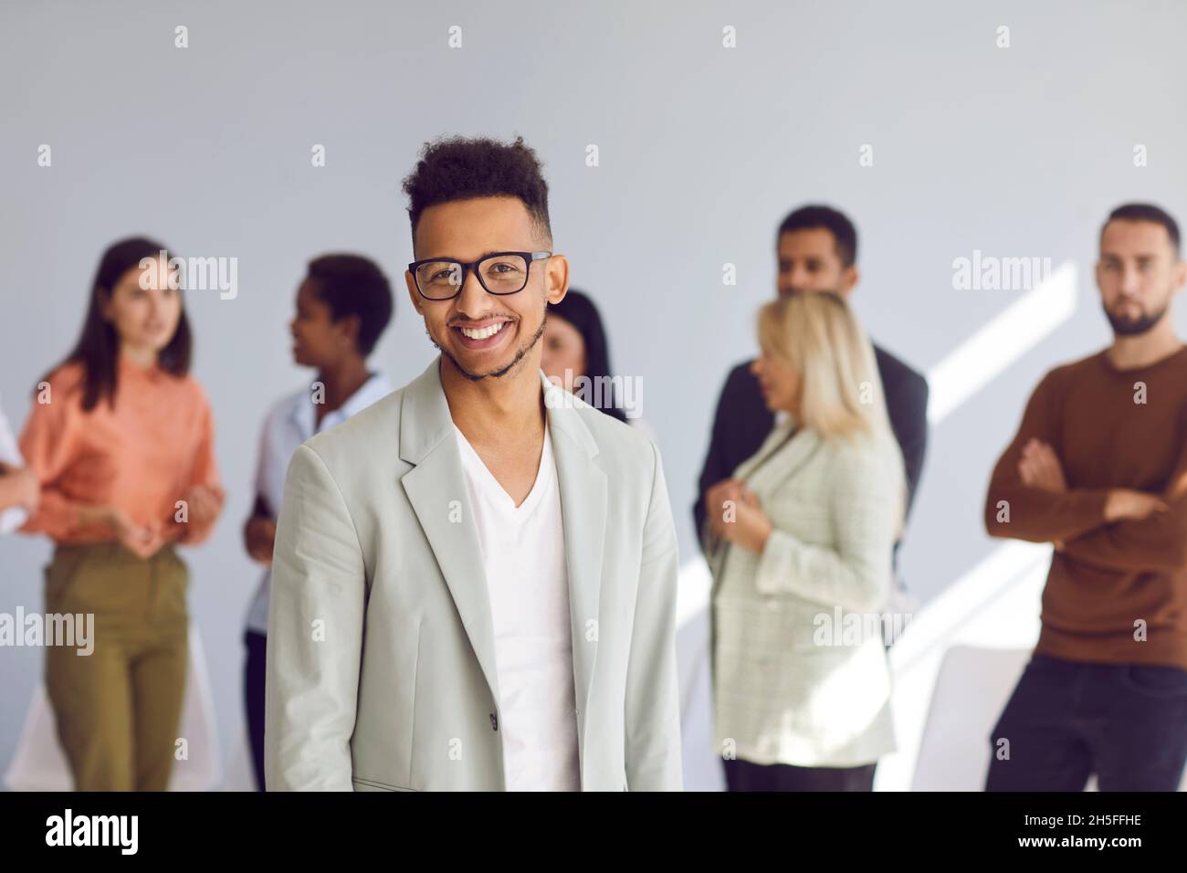 Portrait of positive male employee standing on blurred background of ...