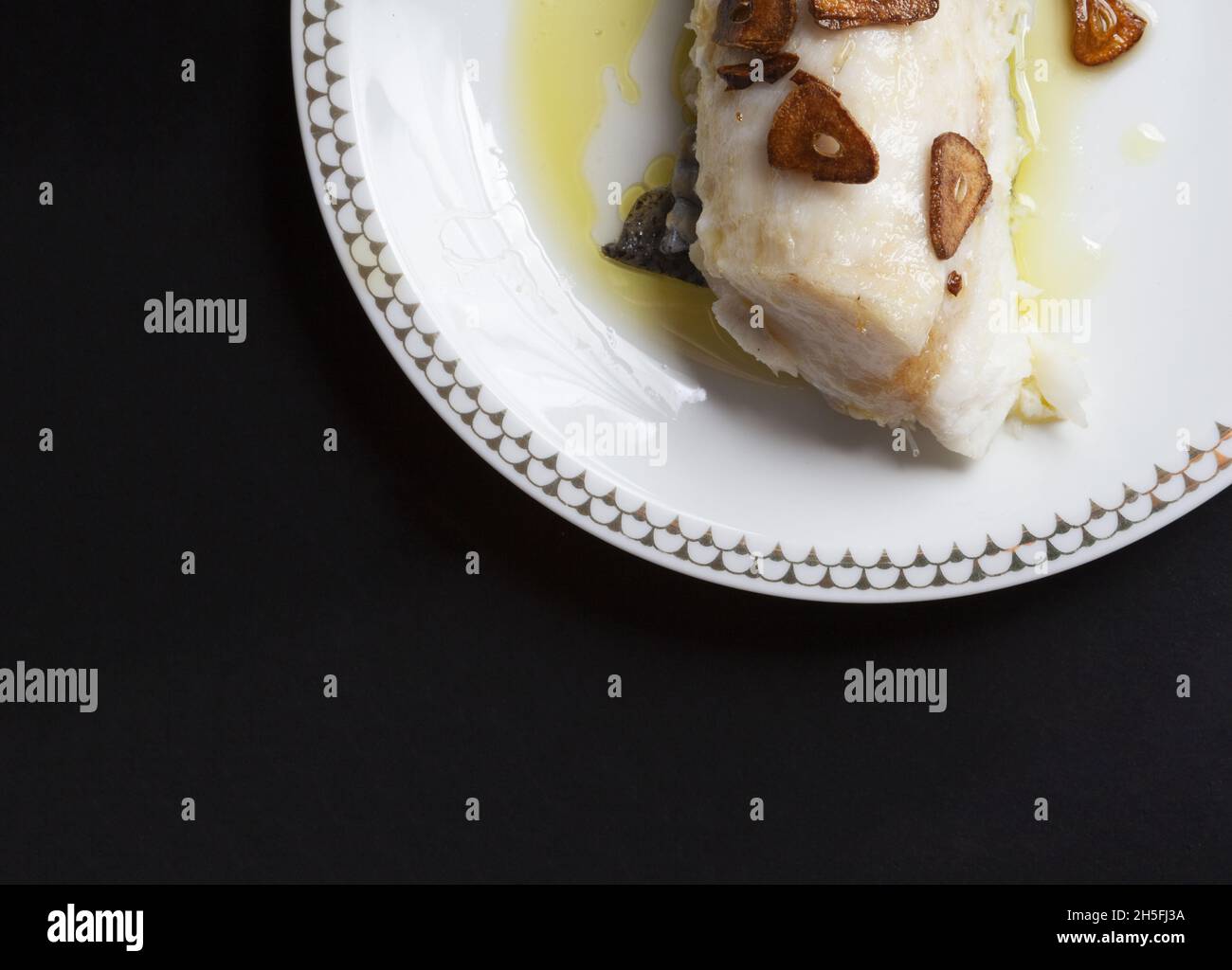 Closeup of the hake head fillet baked with garlic. Homemade food ...