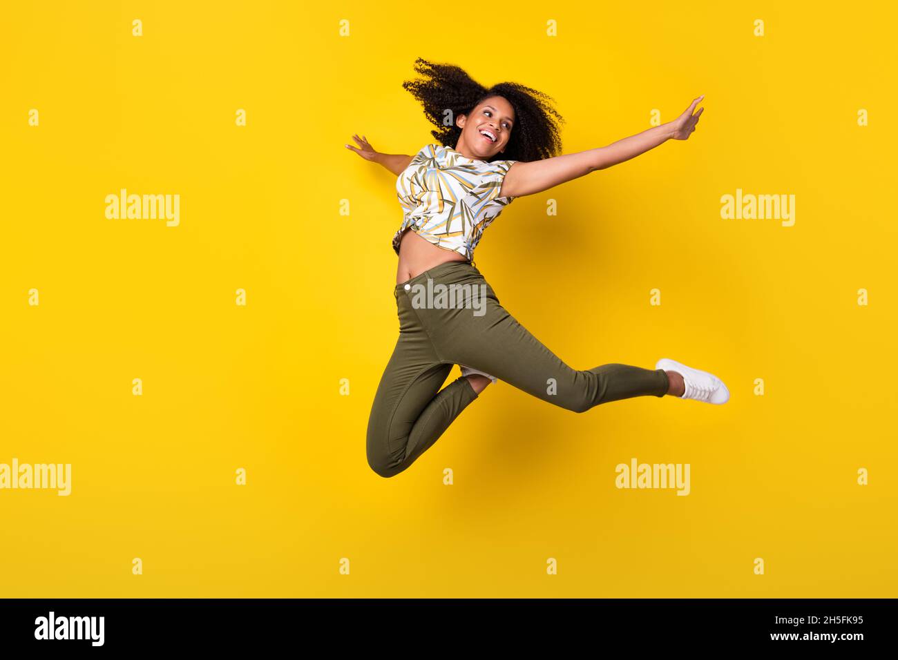 Full size photo of young excited african girl have fun jumper enjoy fly ...