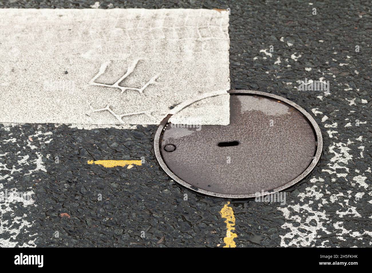 Small metal hatch and road marking, abstract urban photo Stock Photo ...