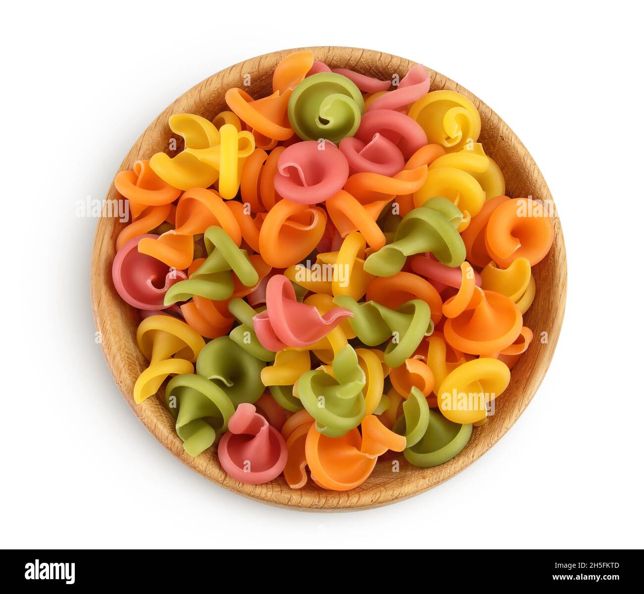 Raw colored pasta in wooden bowl isolated on white background with ...