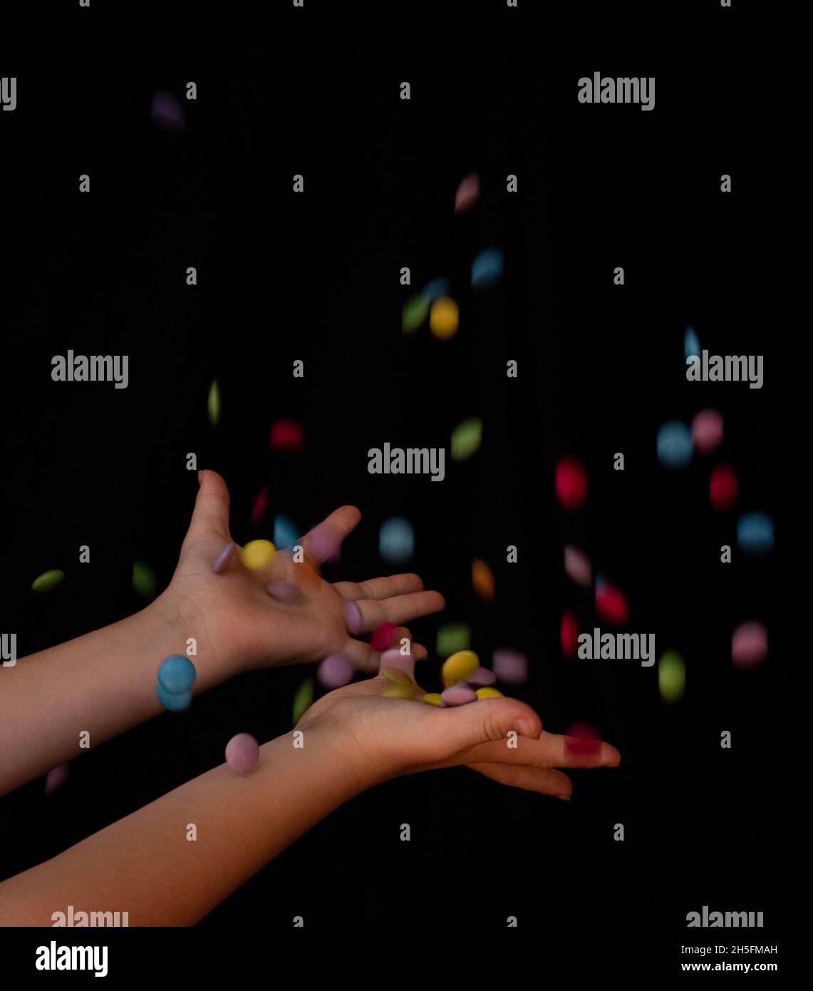 Smarties raining into a child's hands Stock Photo - Alamy