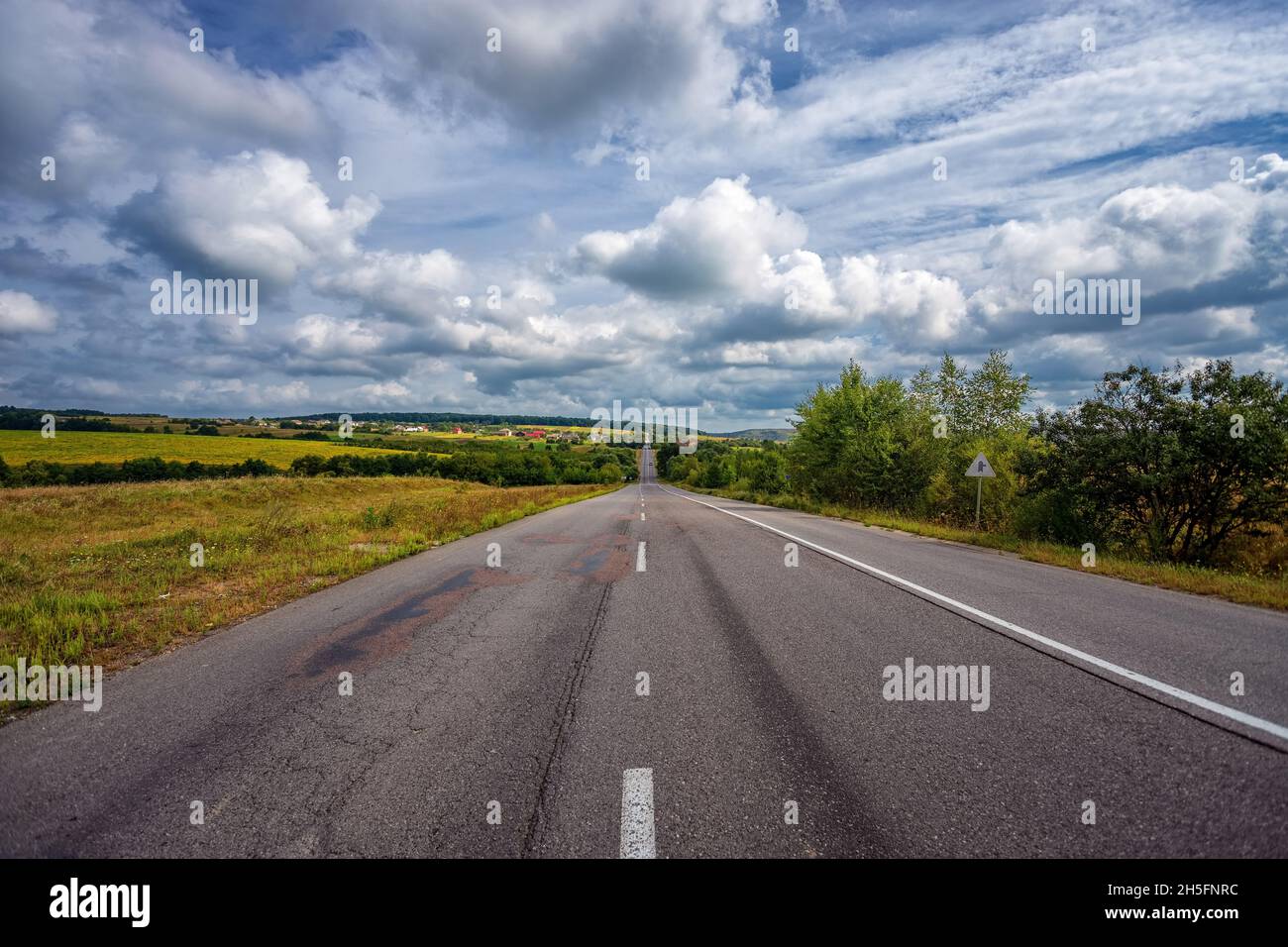 Empty summer highway in a hilly area, on the background of blue sky and ...