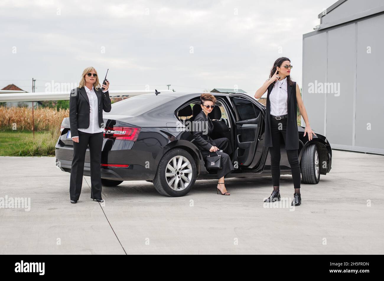 Professional armed team of female and male bodyguards protect celebrity ...