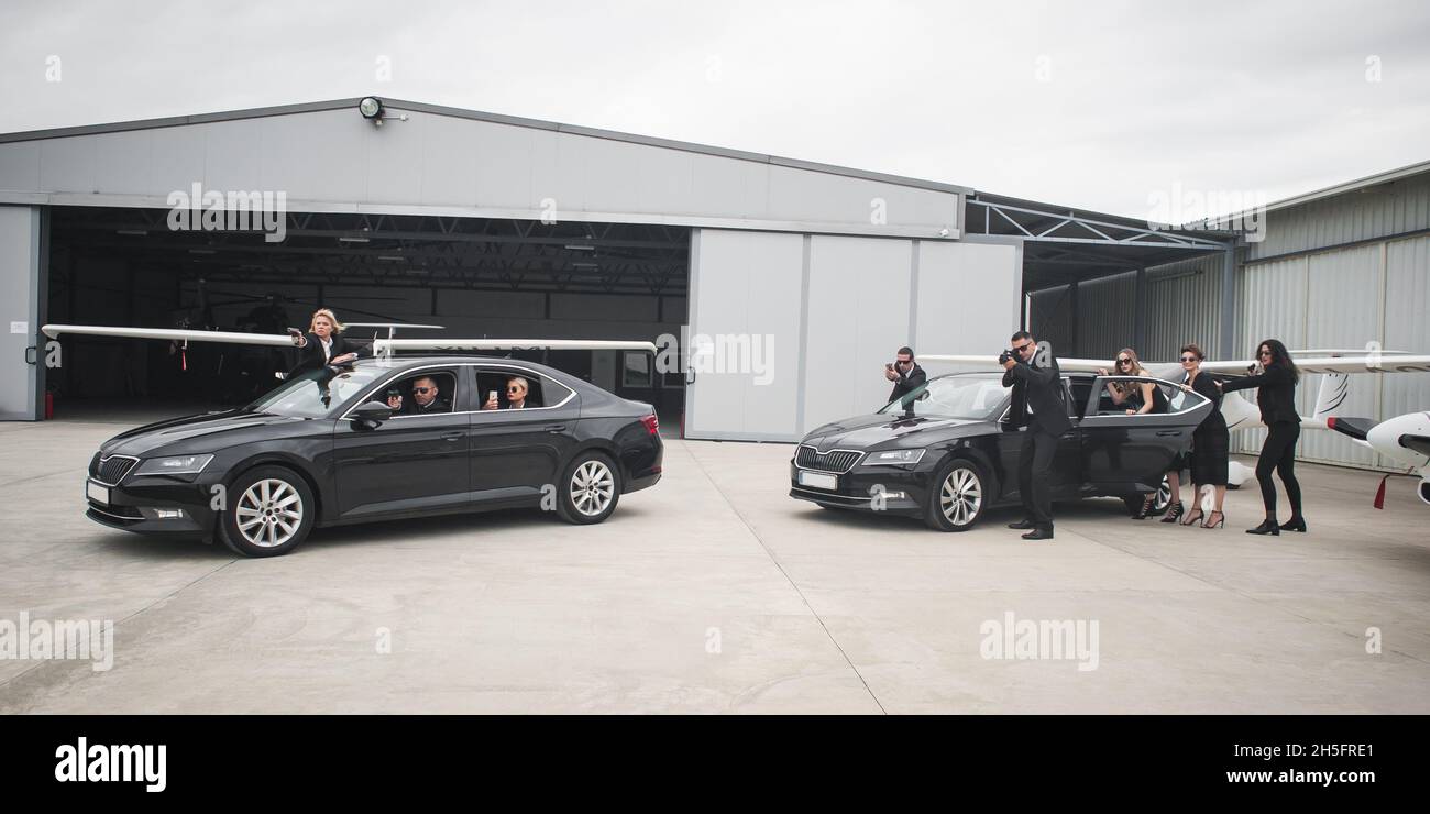 Professional armed team of female and male bodyguards protect celebrity ...