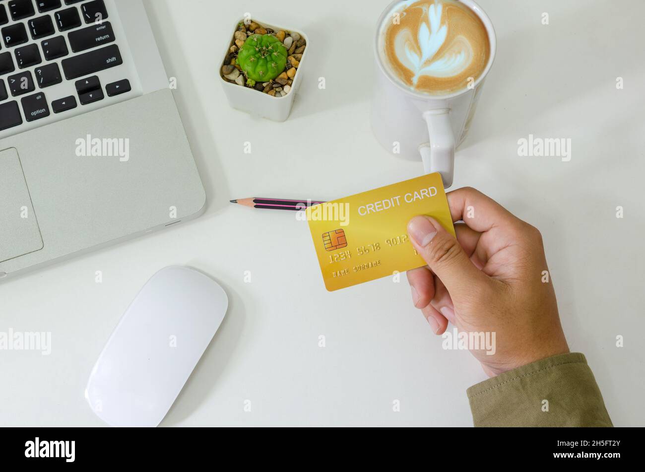 Top view man holding a credit card and on the desk. Laptop computer ...