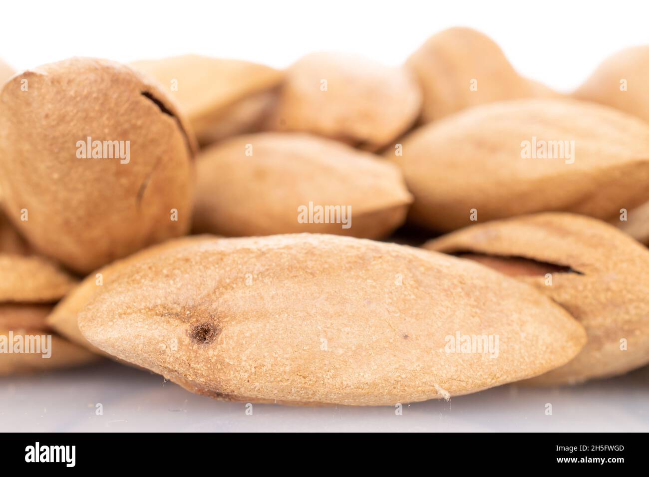 Dried unpeeled almonds, close-up, isolated on white Stock Photo - Alamy