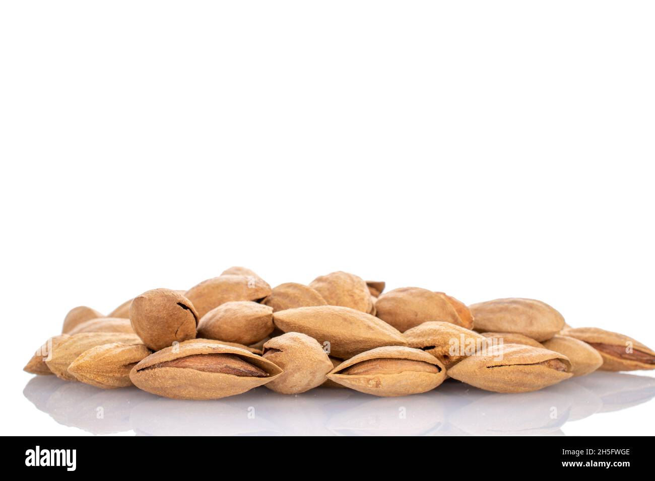 Dried unpeeled almonds, close-up, isolated on white Stock Photo - Alamy
