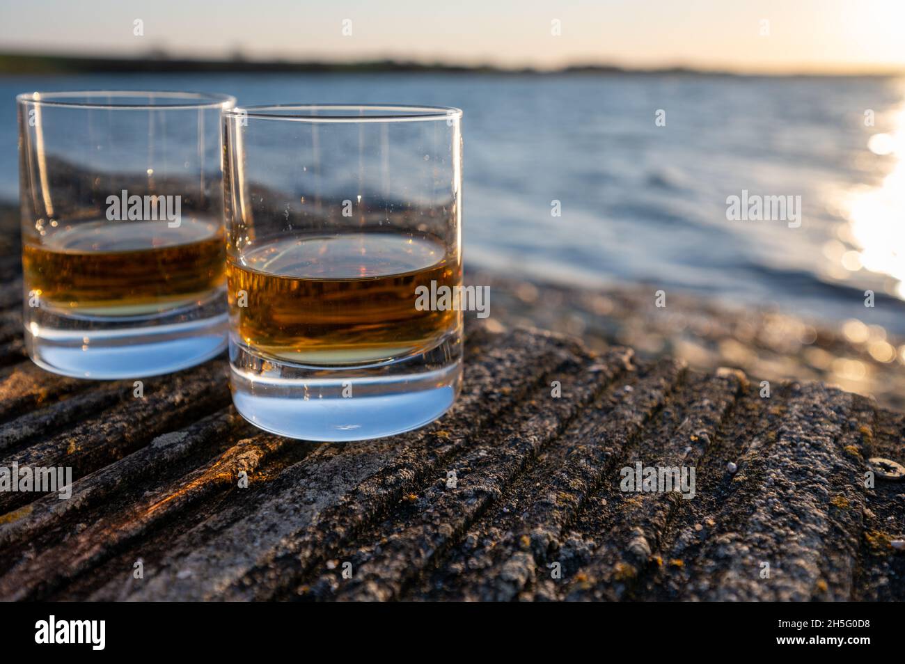 Drinking single malt Scotch whisky at sunset with sea, ocean or river ...