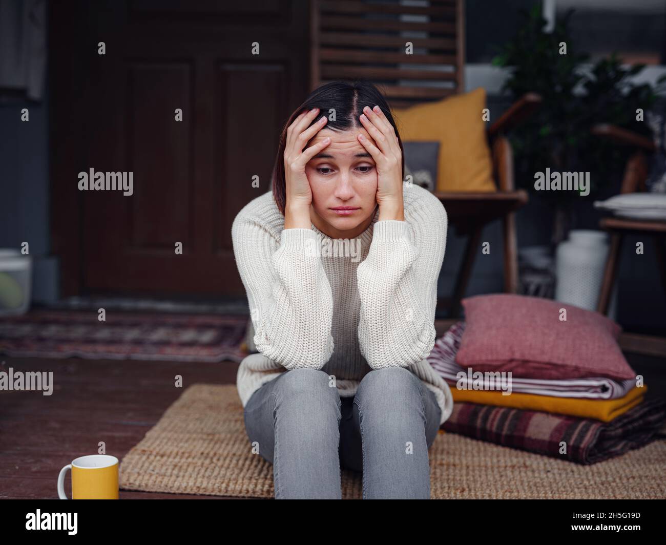 Young depressed asian woman sitting on porch of backyard. She feeling ...