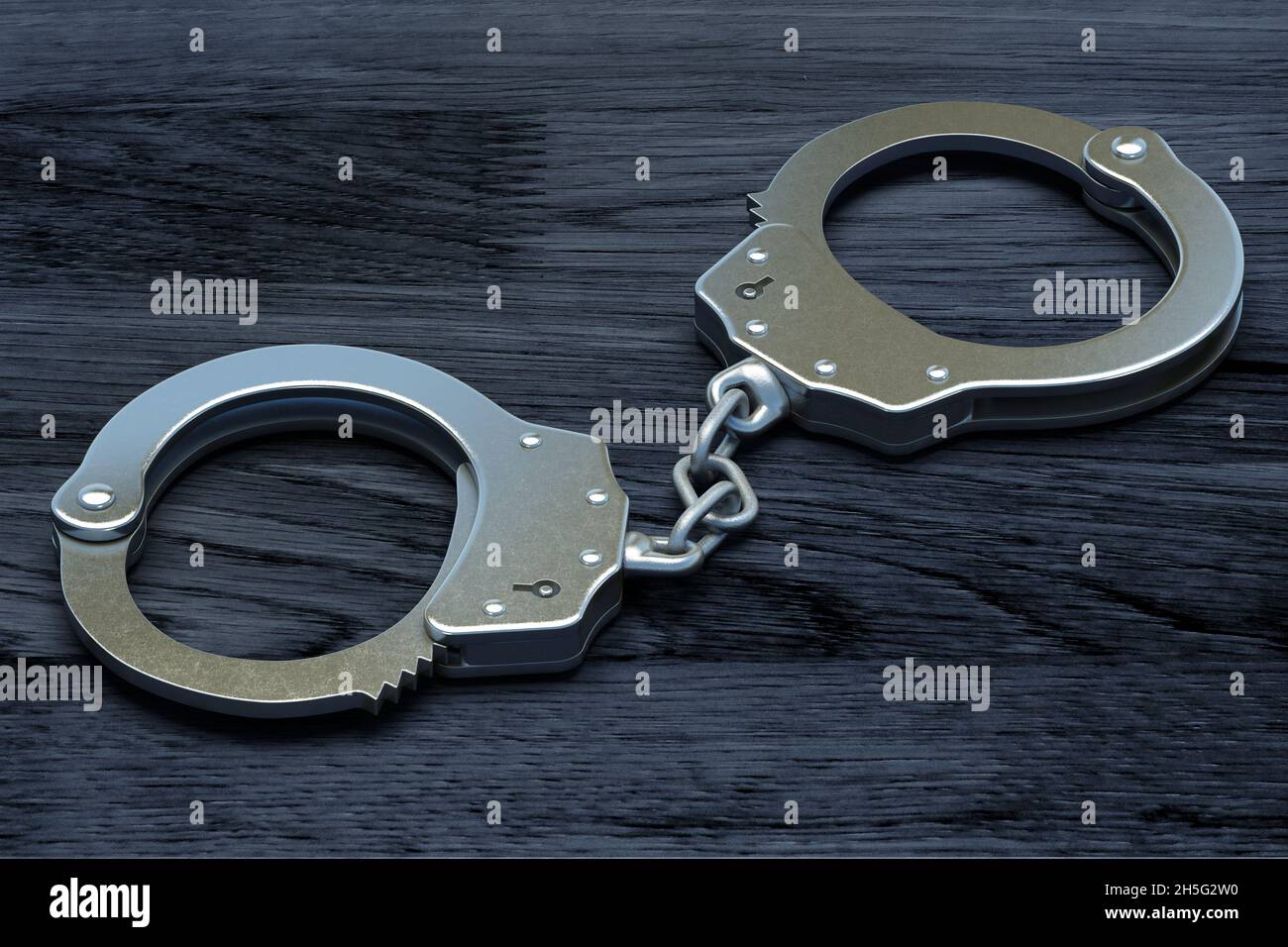 Police metal handcuffs on dark wooden background Stock Photo - Alamy