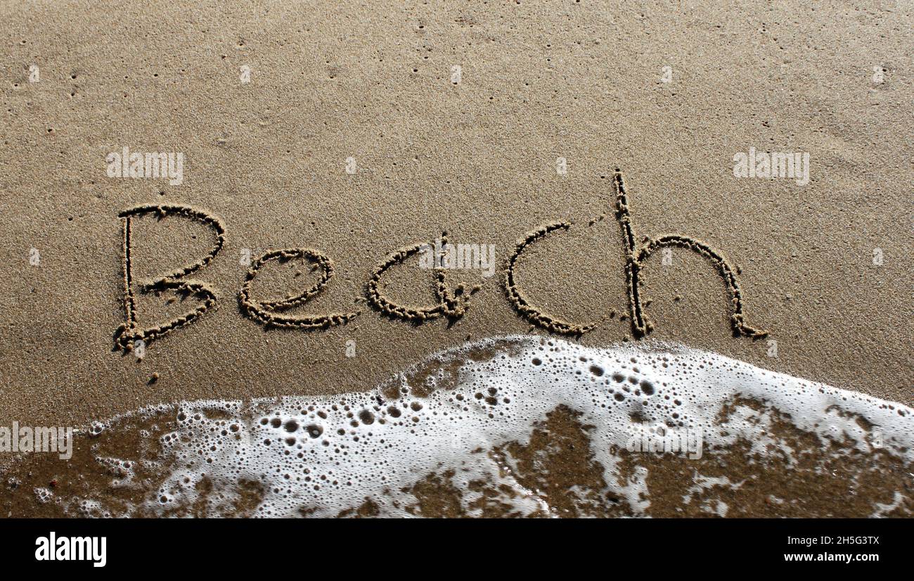 on the beach is carved with letters in the smooth sand the writing ...