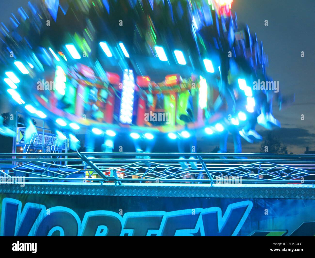 The whirling lights of a Vortex fairground ride as it spins the ...