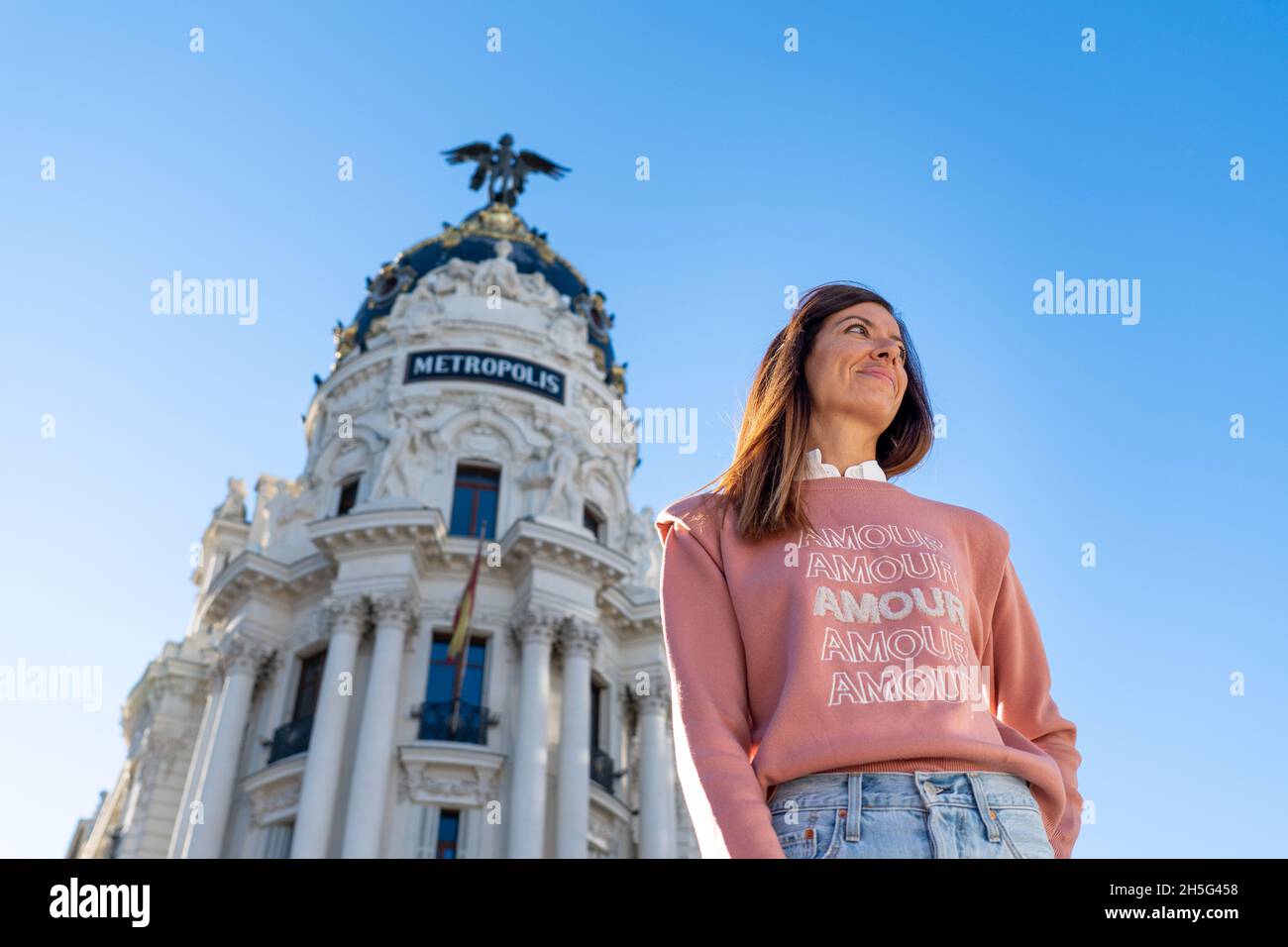 Woman in pink sweater and jeans posing in the Metropolis building on ...