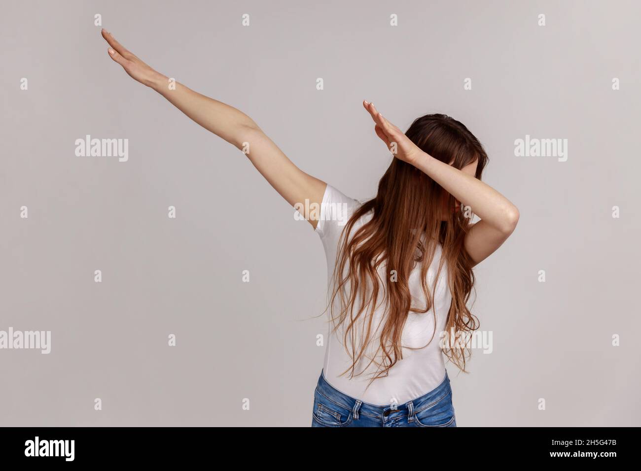 Portrait of woman showing dab dance move, famous internet gesture of ...
