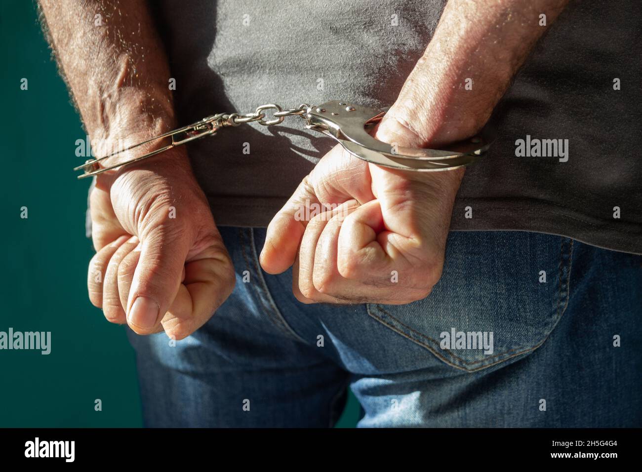 Detained man with hands behind his back Stock Photo - Alamy