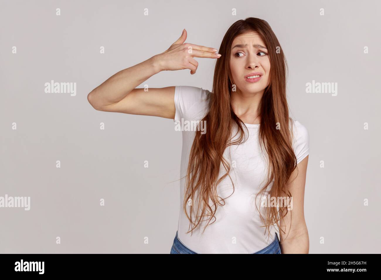 Portrait of desperate woman, pointing finger gun to head, shooting ...