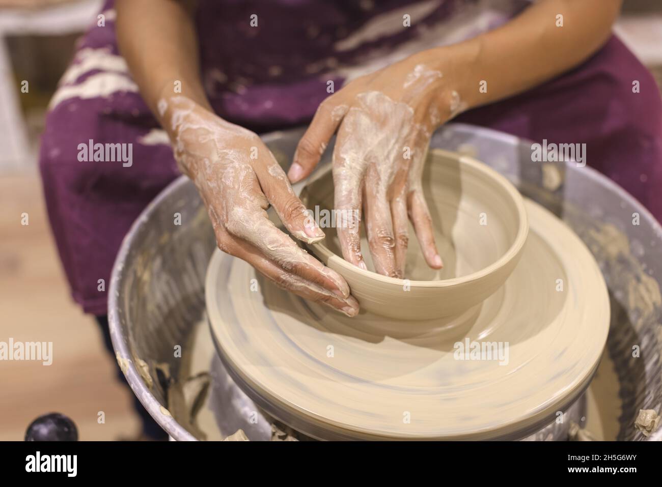 Female pottery artist shapes the clay on pottery wheel. Creative ...