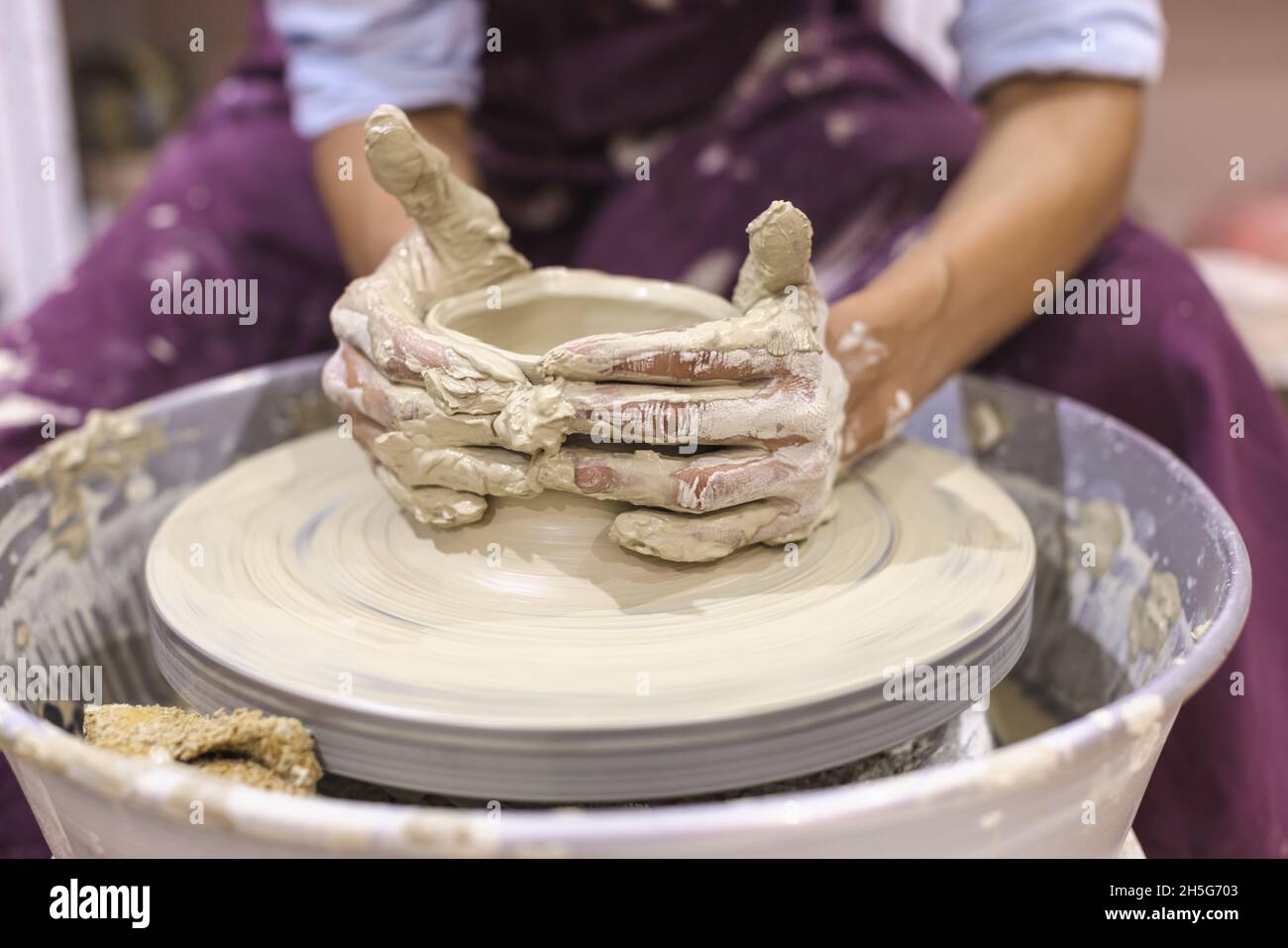 Female pottery artist shapes the clay on pottery wheel. Creative ...