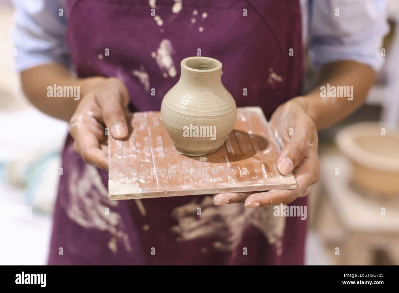 Pottery artist showing clay vase in ceramic studio. Creative handmade ...