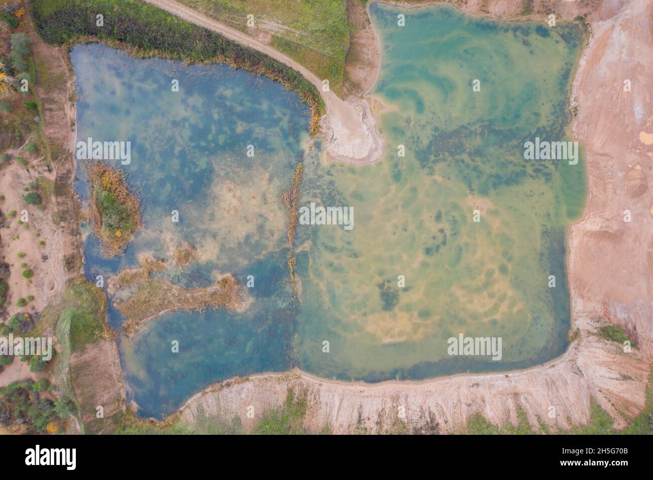 Aerial top down view of an opencast sand, gravel mine quarry full with ...