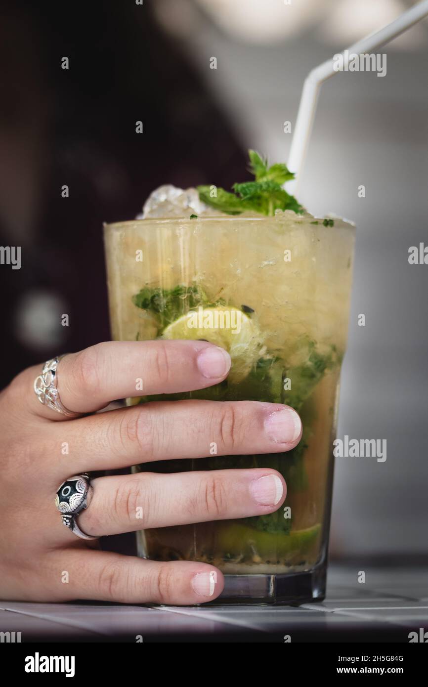 Selective of a glass of mojito in a hand of a female Stock Photo - Alamy